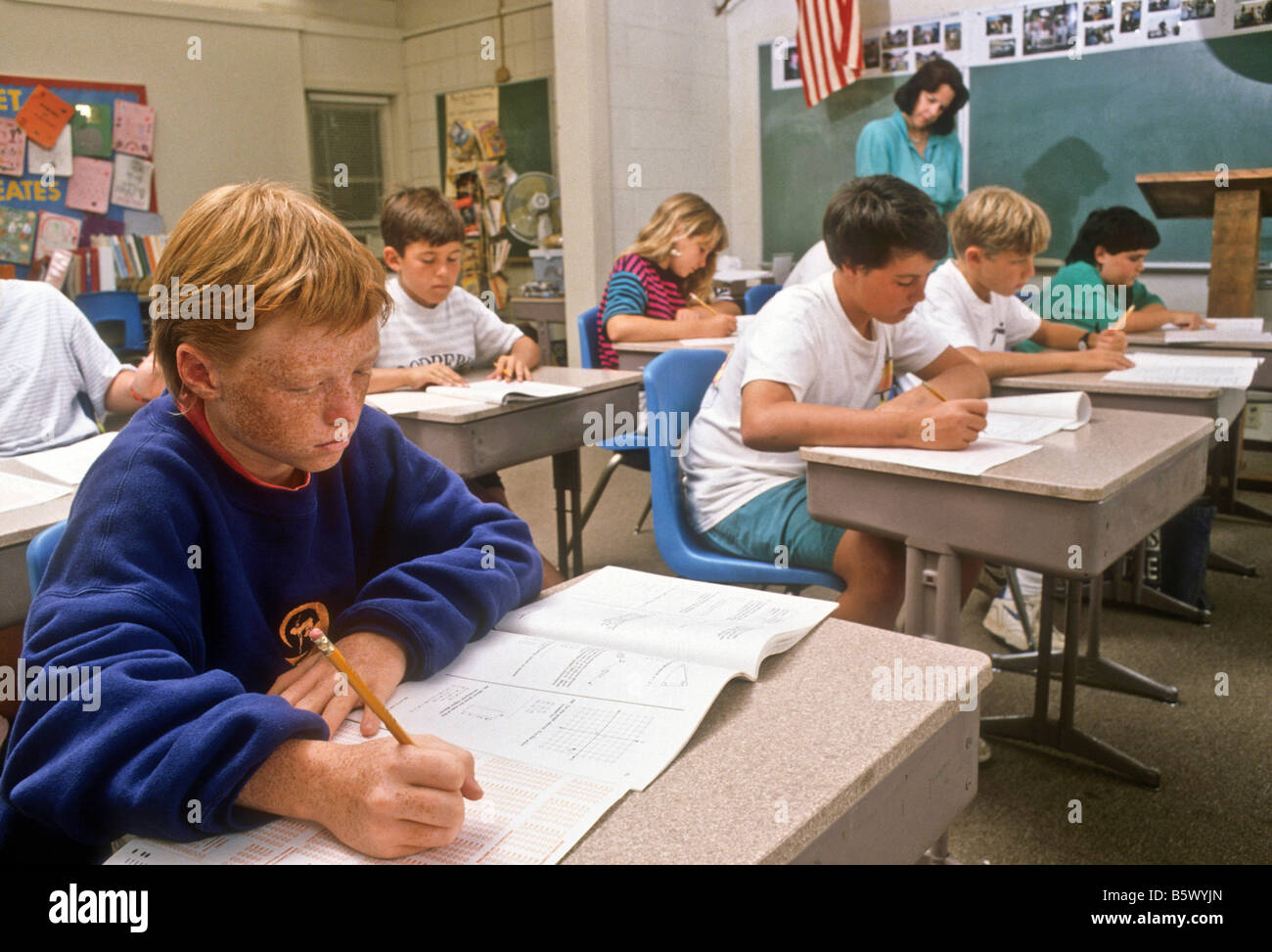 Junior high school class takes exam as teacher watches Stock Photo - Alamy