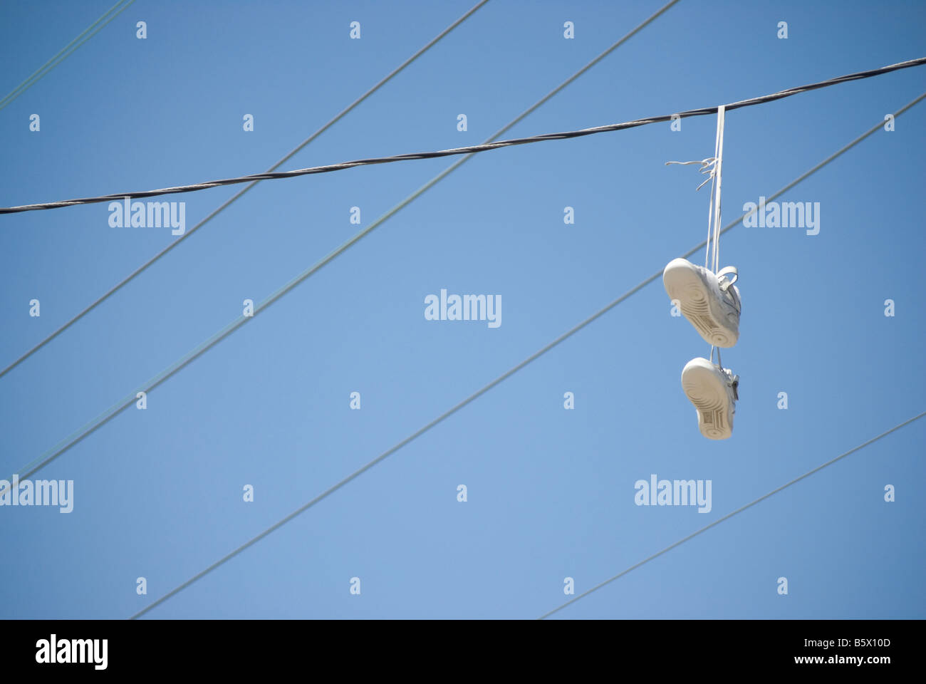 A pair of white shoes hang from the electrical wire where they were ...