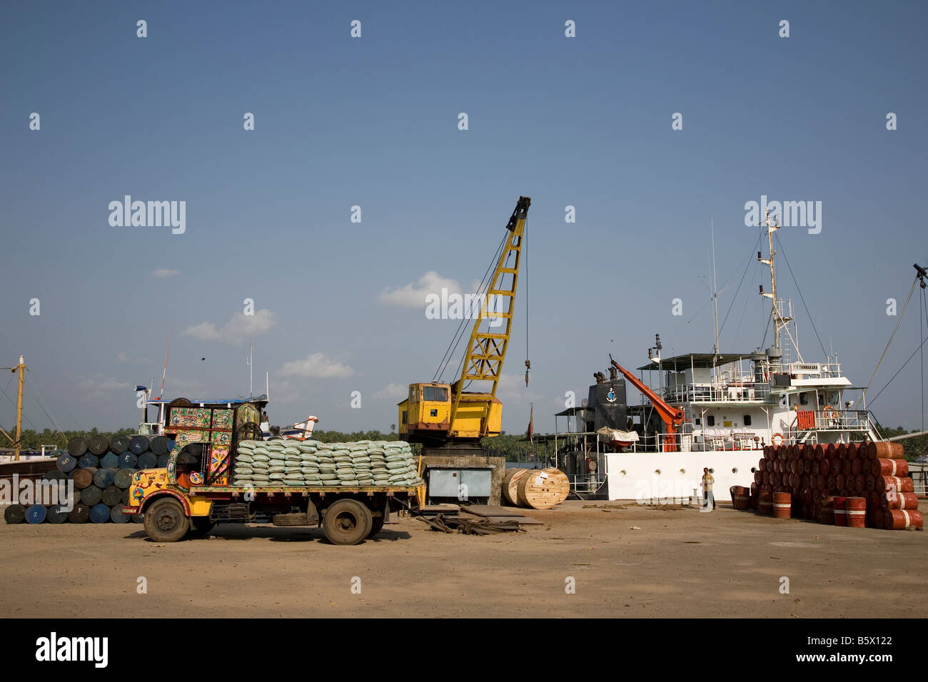 The port of Beypore in Kerala, India. Cranes and teams of workers help ...