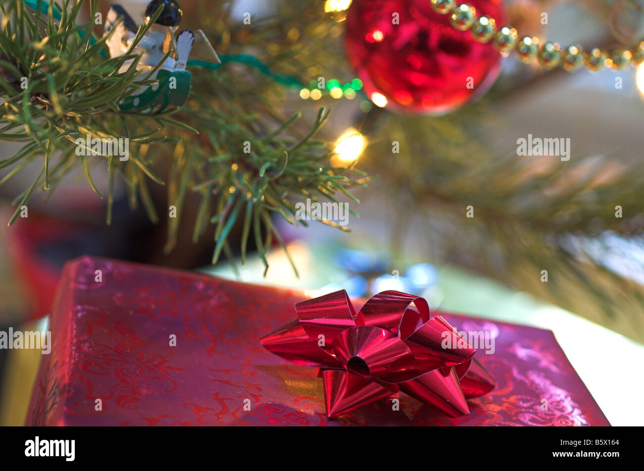 A traditional fresh pine Christmas tree with prettily wrapped gifts and ...