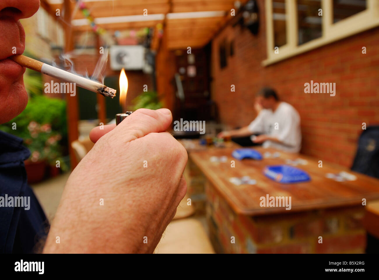 A man lights up a cigarette in a lean to built to beat the smoking ban ...