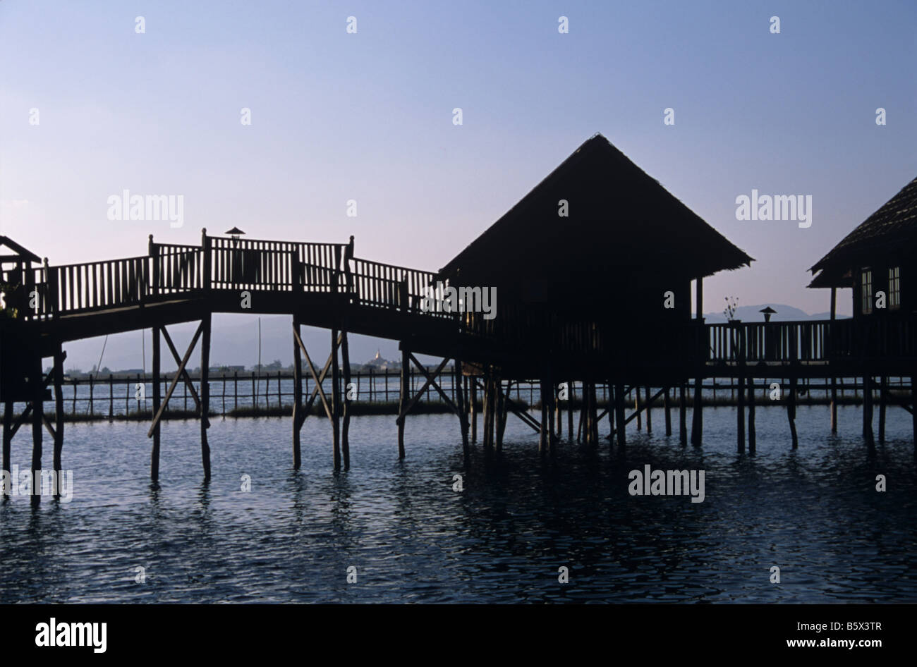 Stilt Bungalow and Wooden Walkway Silhouetted Against Morning Sky ...