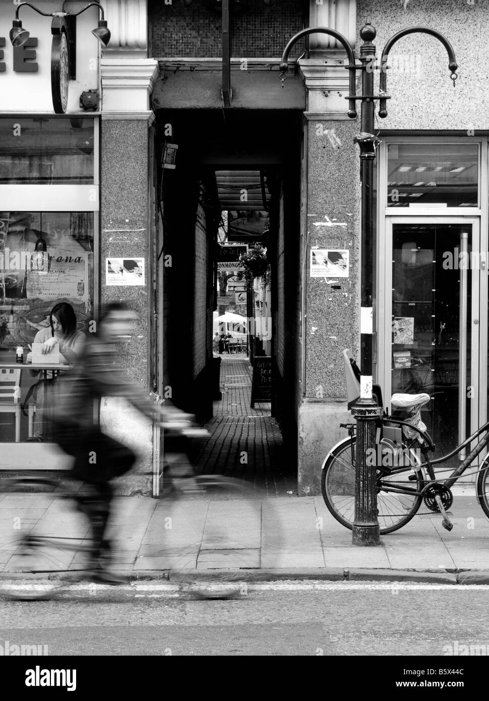 Black and white shot of cyclist cycling past an alleyway, Oxford ...