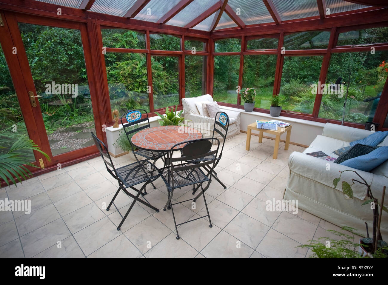 conservatory tables chairs plants room in house next to garden Stock ...