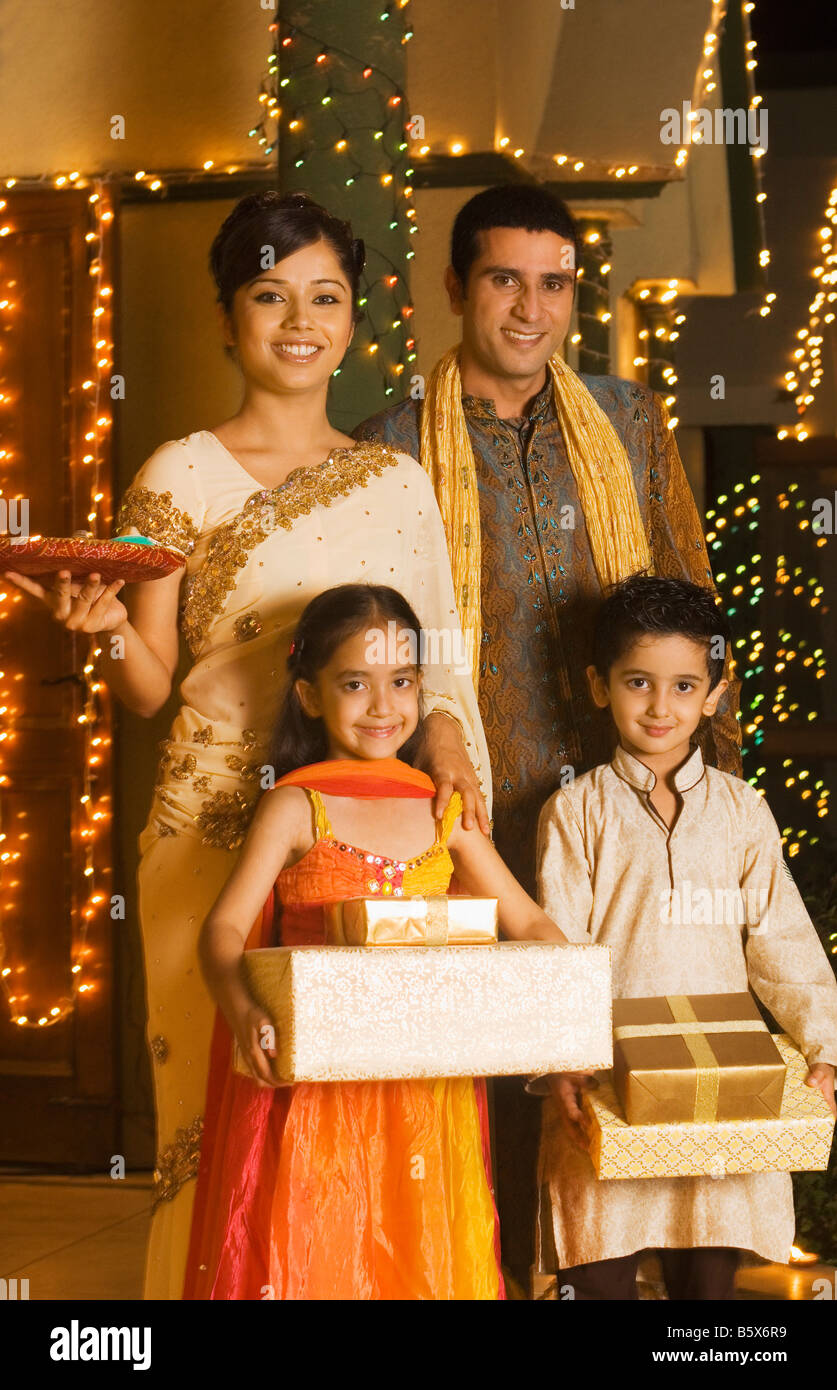 Children holding gifts with their parents holding religious offering ...