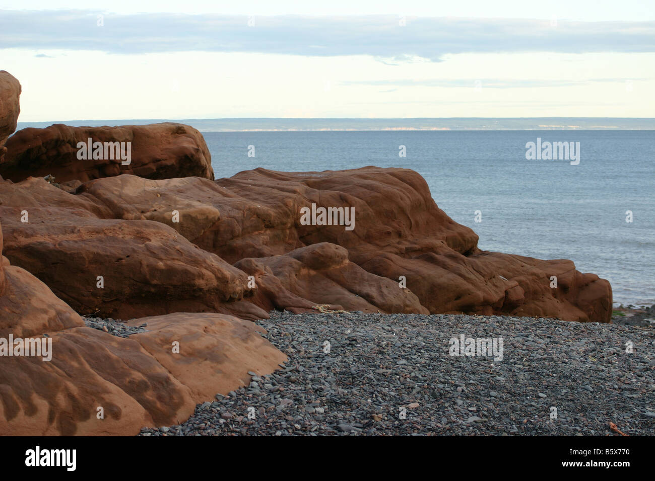 Huge red waterworn sandstone rock formations on the beach of the Bay of ...