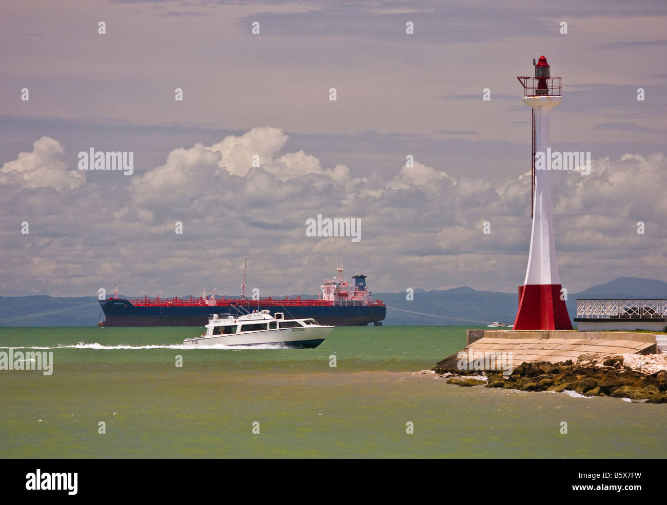 BELIZE CITY BELIZE Boat passes oil tanker ship and Fort George ...
