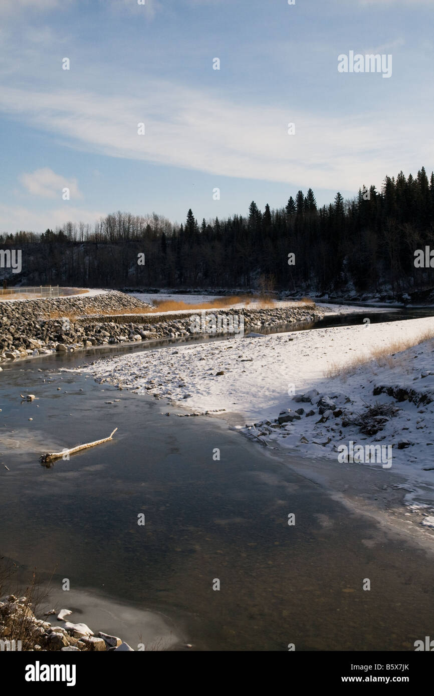 A landscape winding river scene with a floating log in the winter with ...