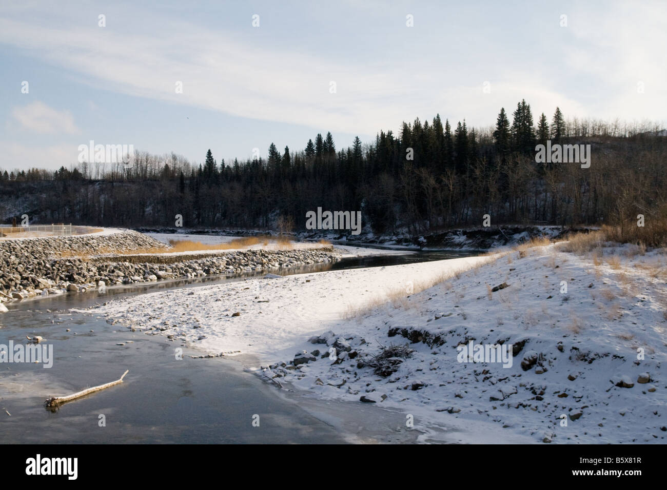A landscape winding river scene with a floating log in the winter with ...