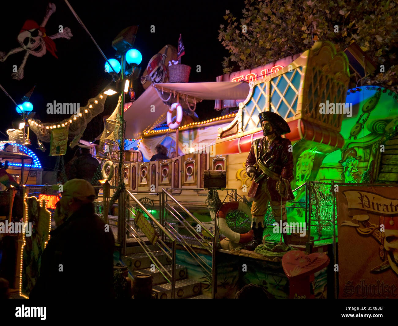 fair with lightened racing amusement rides in different colours in the ...