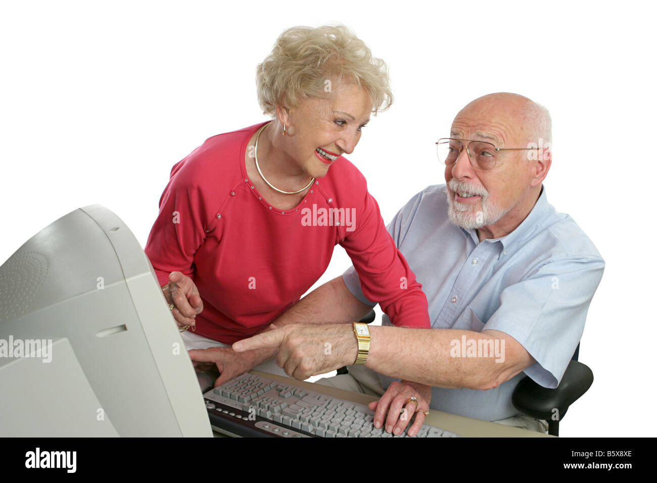 A senior lady teaching a senior man how to use the computer He has a ...
