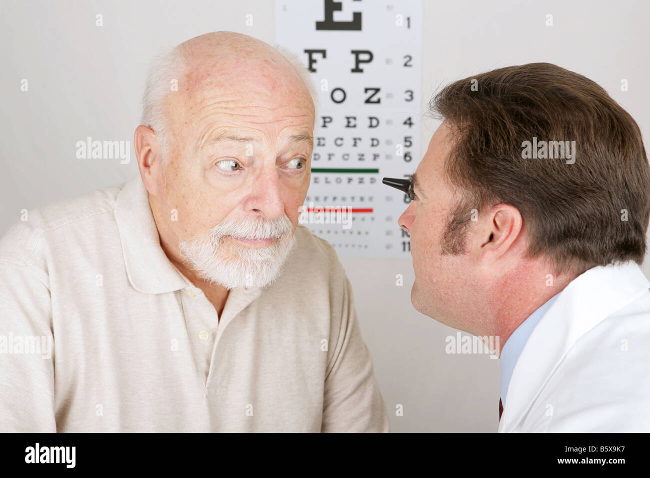 Optician using and ophthalmoscope to look into a patient s eyes Stock ...
