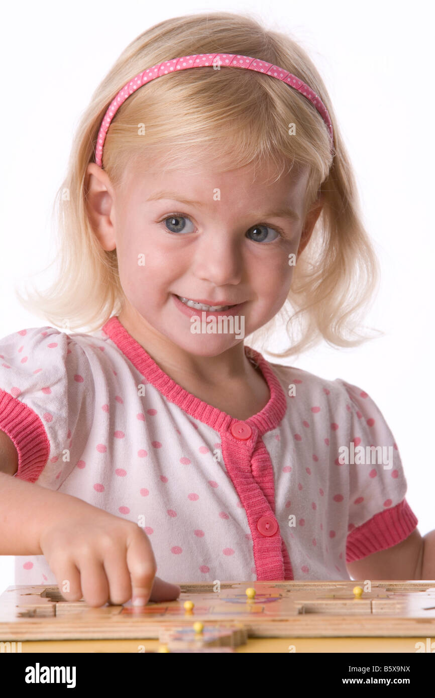 Little blond girl with a puzzle Stock Photo - Alamy