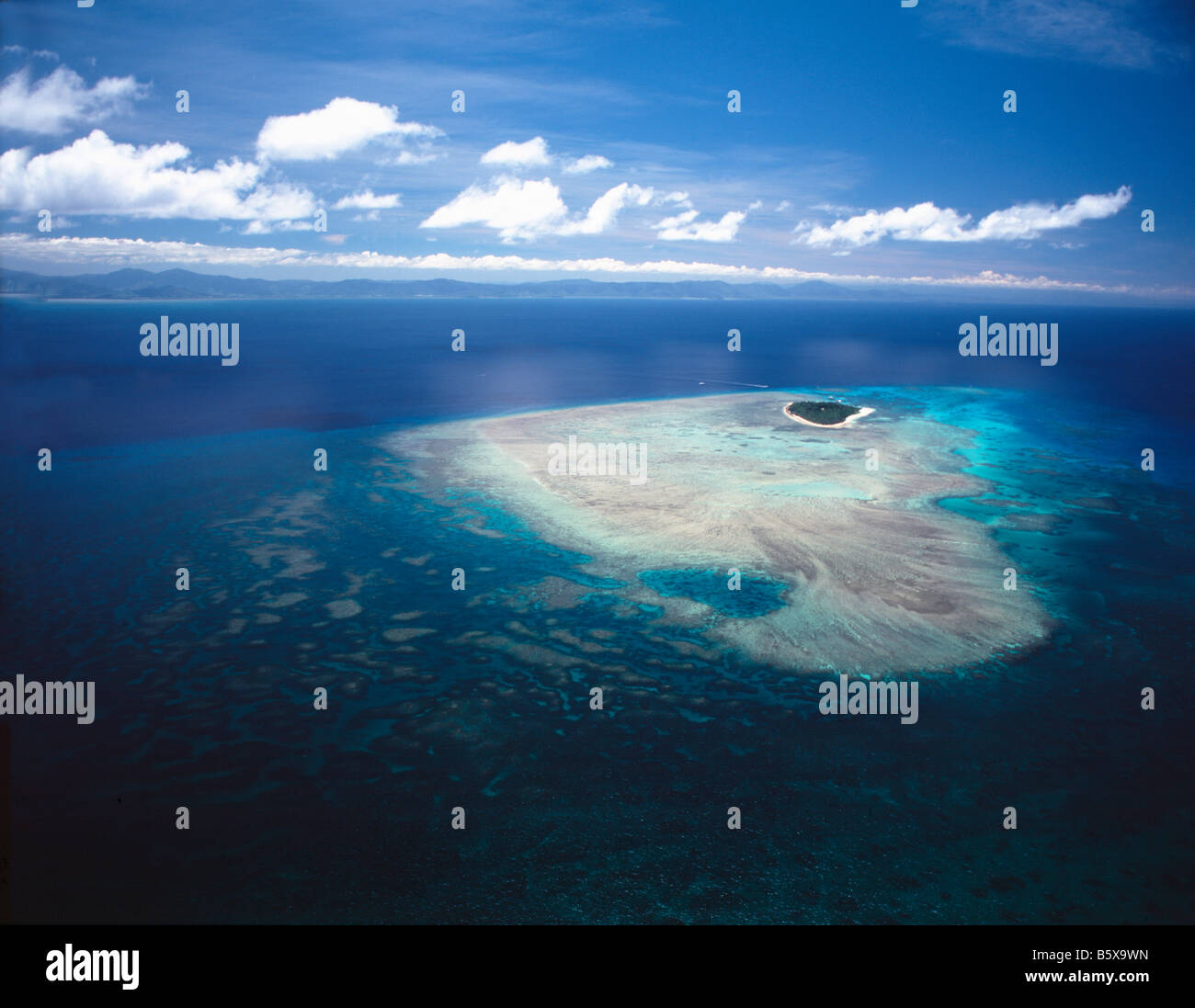 Aerial view of a beautiful tropical atoll with vibrant turquoise waters ...