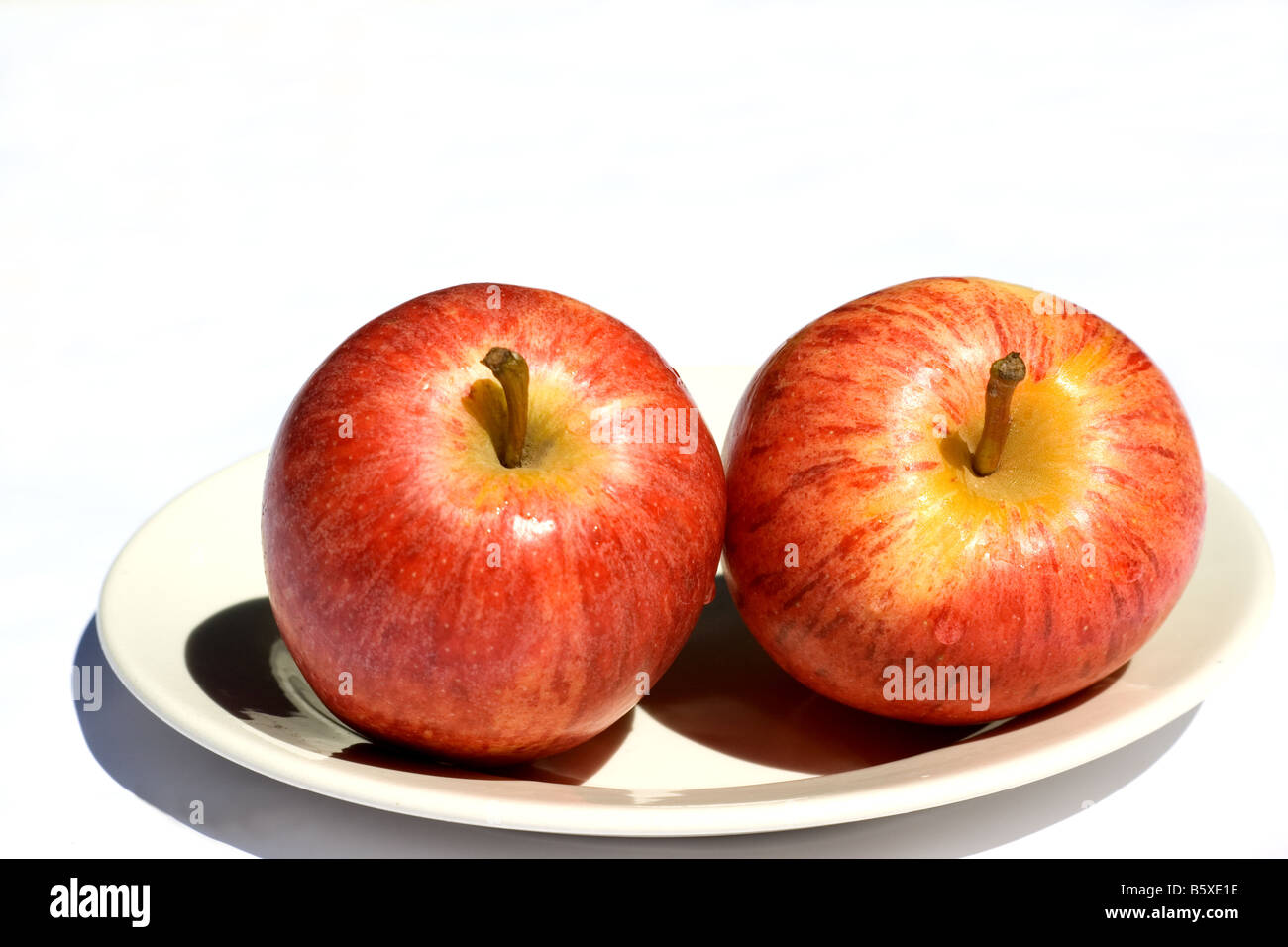 Two red apples on white background Stock Photo - Alamy