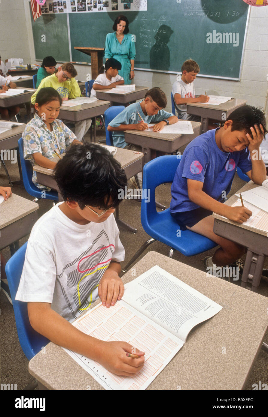 Junior high school class takes exam as teacher watches Stock Photo - Alamy