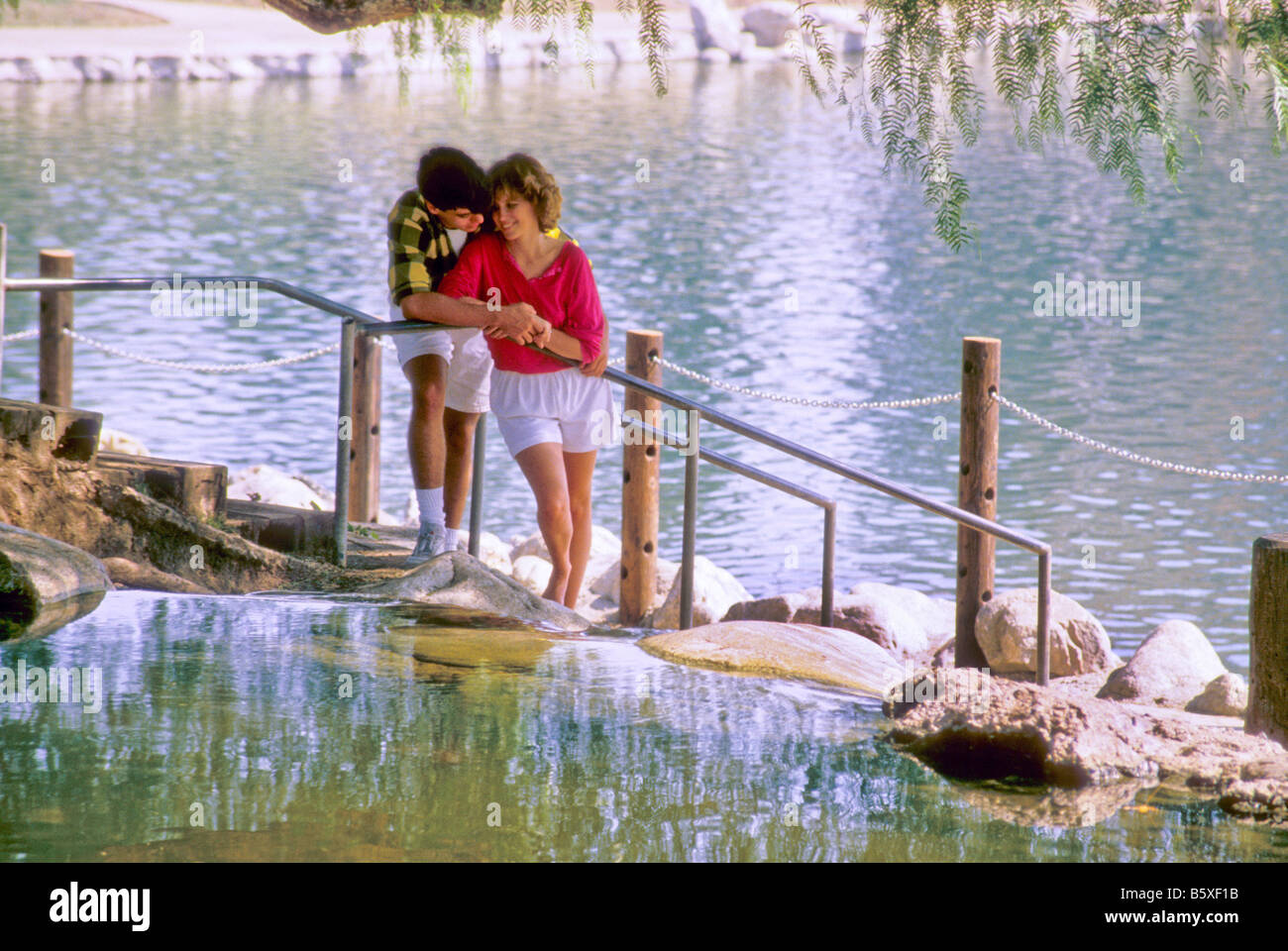 Teen couple cuddle an hug in city park near lake Stock Photo - Alamy
