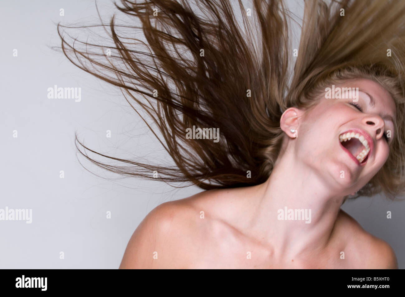 Happy blonde woman flinging hair Stock Photo - Alamy