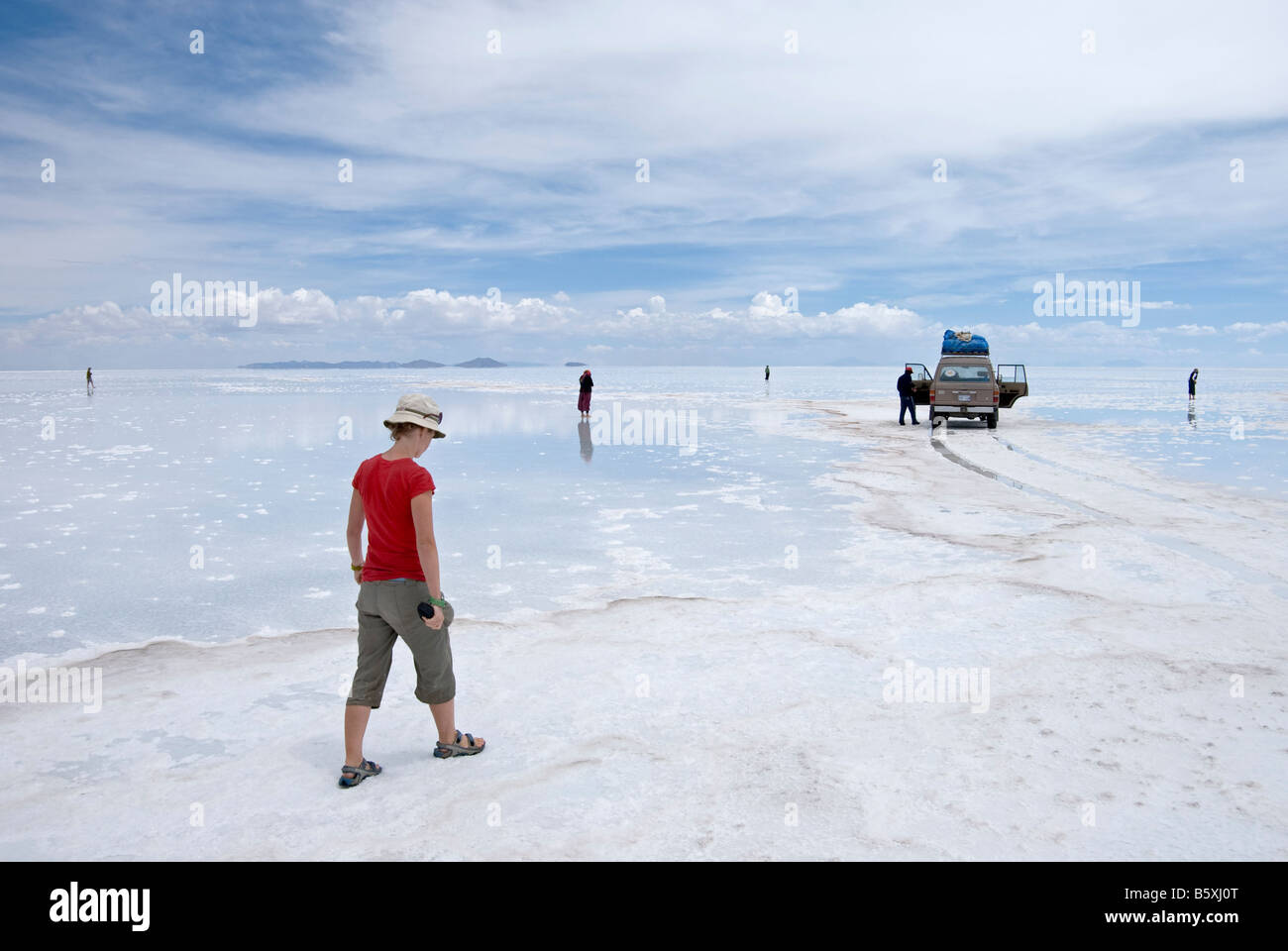 A tourist walks across the flooded Bolivian salt plains Salar de Uyuni ...