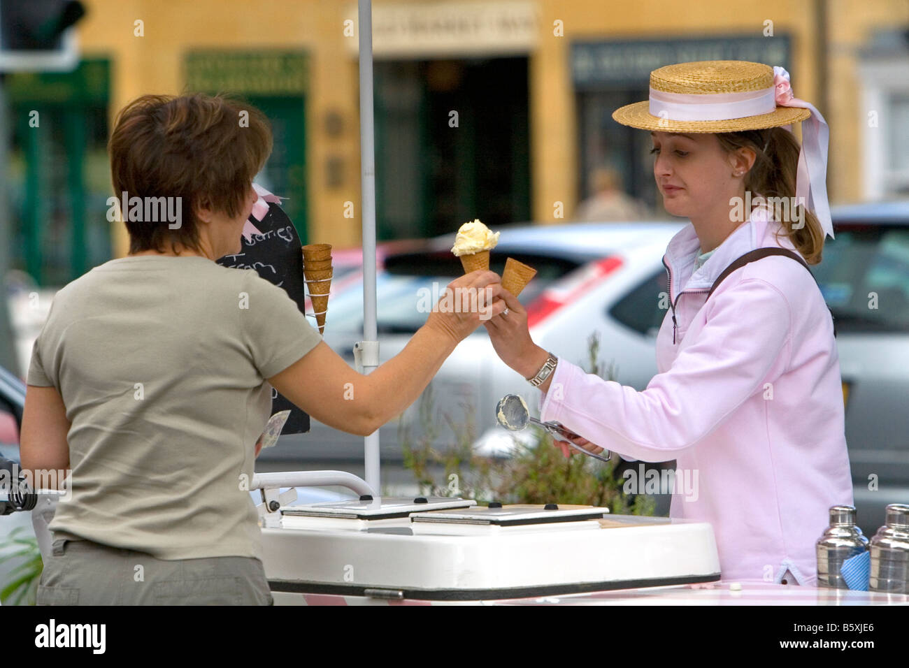 Female street vendor selling ice cream in the town of Moreton in Marsh ...