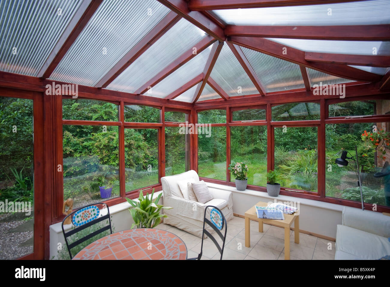 conservatory tables chairs plants room in house next to garden Stock ...