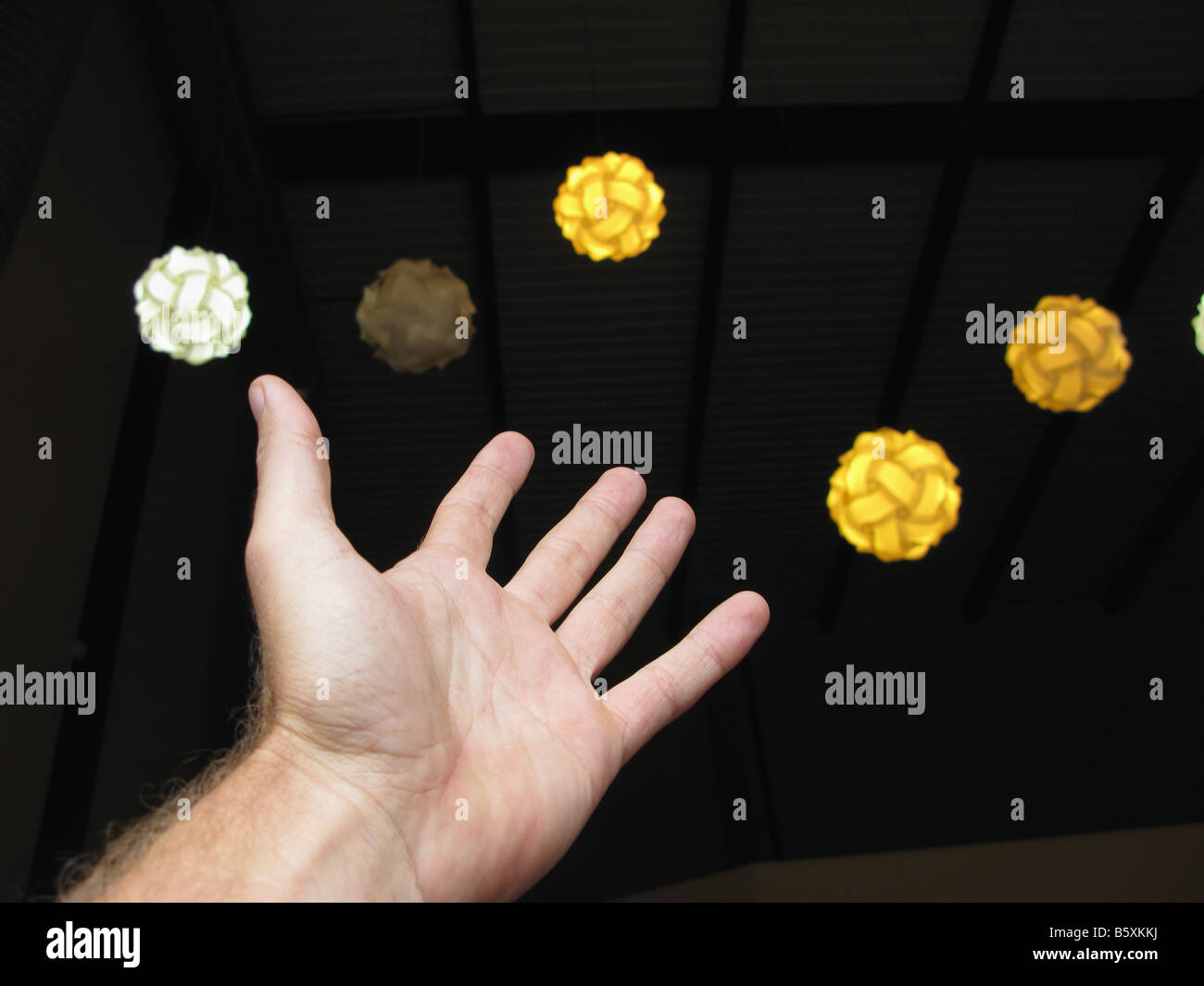 Hand reaching out to ceiling with lights Stock Photo - Alamy
