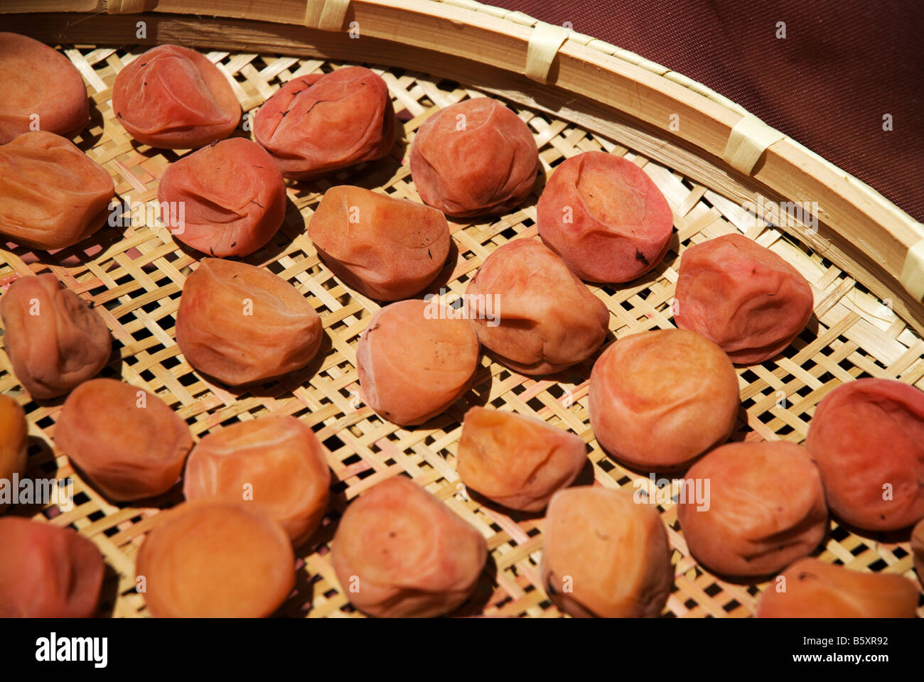 Drying ume boshi or Japanese salted plums prunus mume on a wicker ...