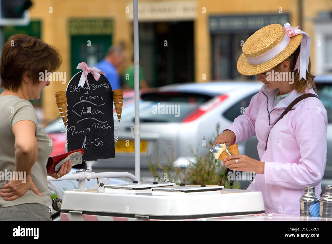 Female street vendor selling ice cream in the town of Moreton in Marsh ...