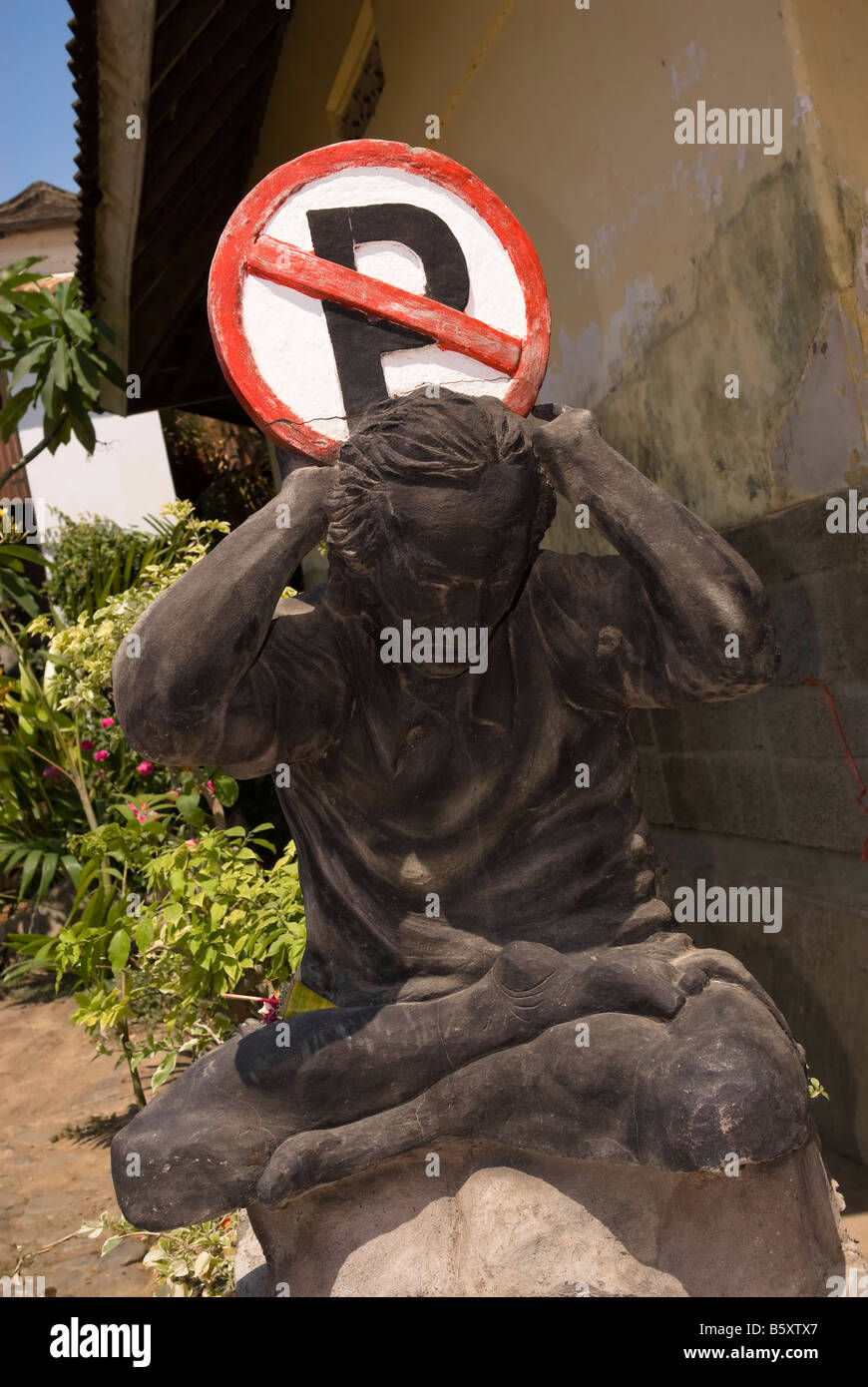 No parking sign on top of a sculpture or statue of a man appearing to ...