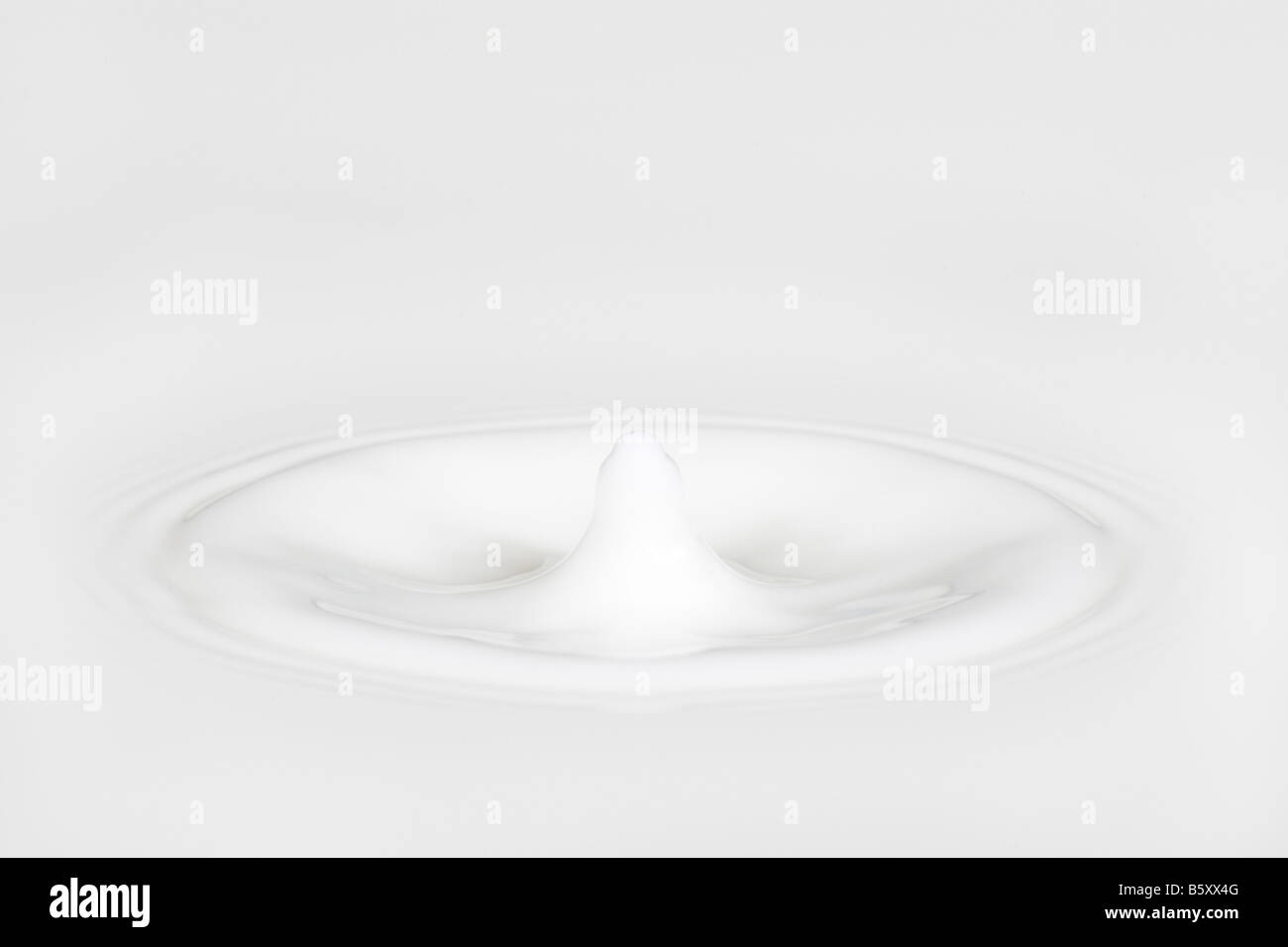 Milk drop splashing down Stock Photo - Alamy