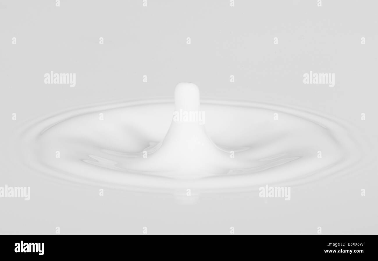 Milk drop splashing down Stock Photo - Alamy