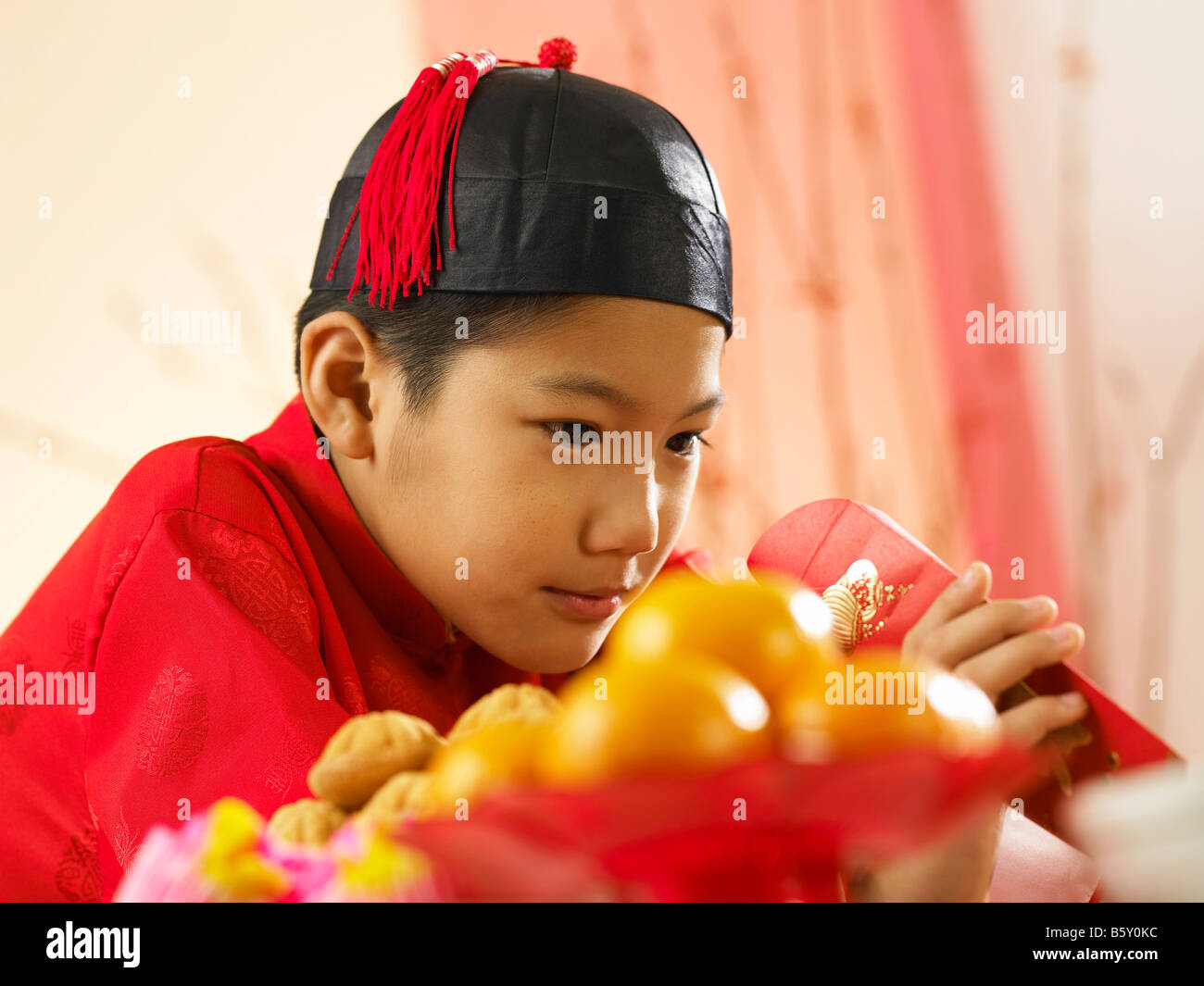 boy holding red packet and looking for money Stock Photo - Alamy