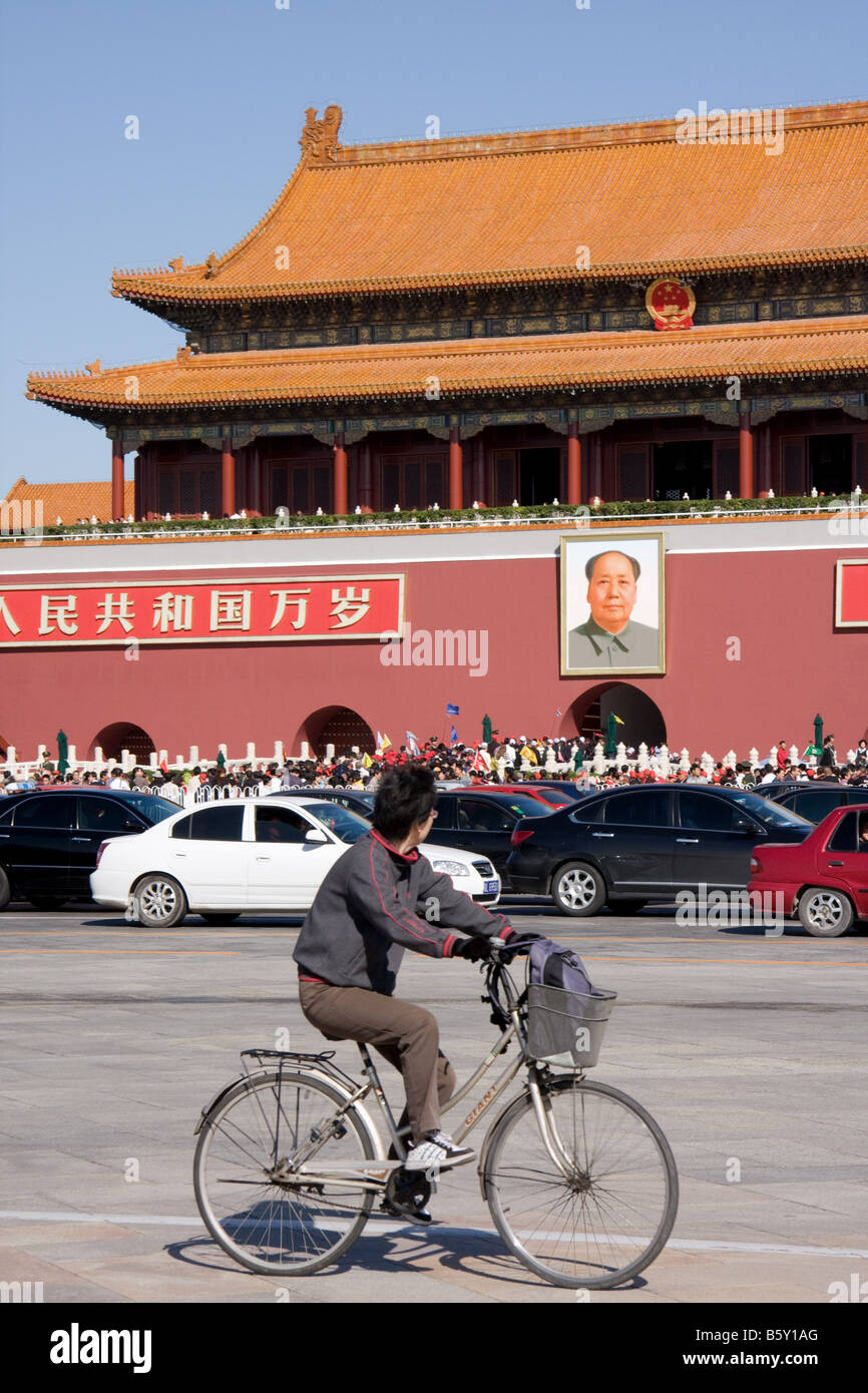 Asian man riding bicycle on traffic street in front of Tiananmen gate ...