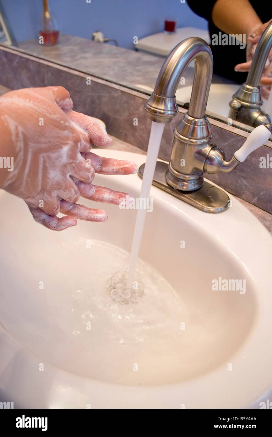 A person washing their hands in the bathroom sink Stock Photo - Alamy