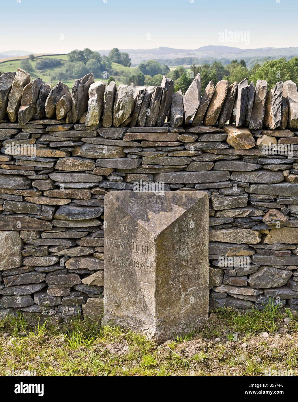 Ancient milestone and drystone walling next to the A590 dual ...