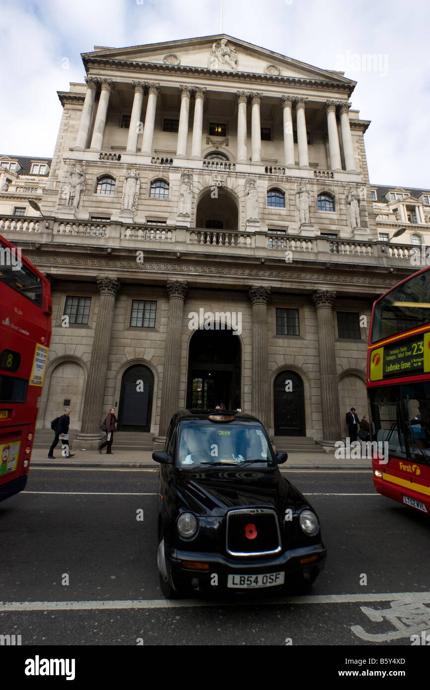 Taxi turning between two buses outside Bank of England building ...