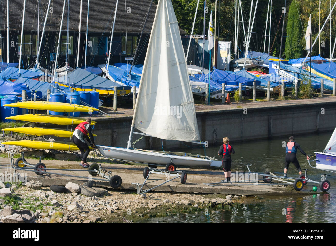 Man and Boy People Landing a Sailing Dinghy onto a trailer on a Slipway ...