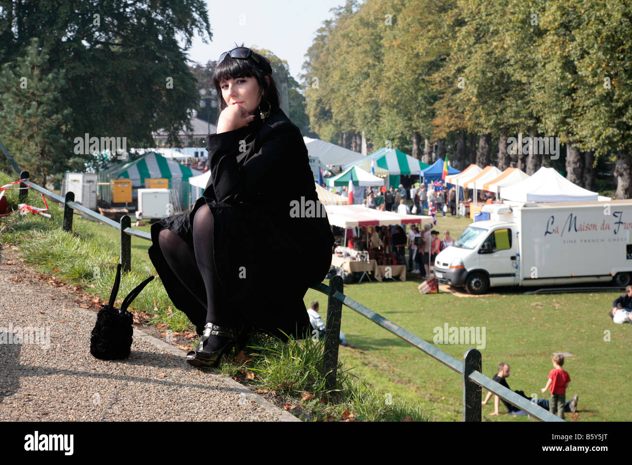 A girl sitting on railings, waiting Stock Photo - Alamy