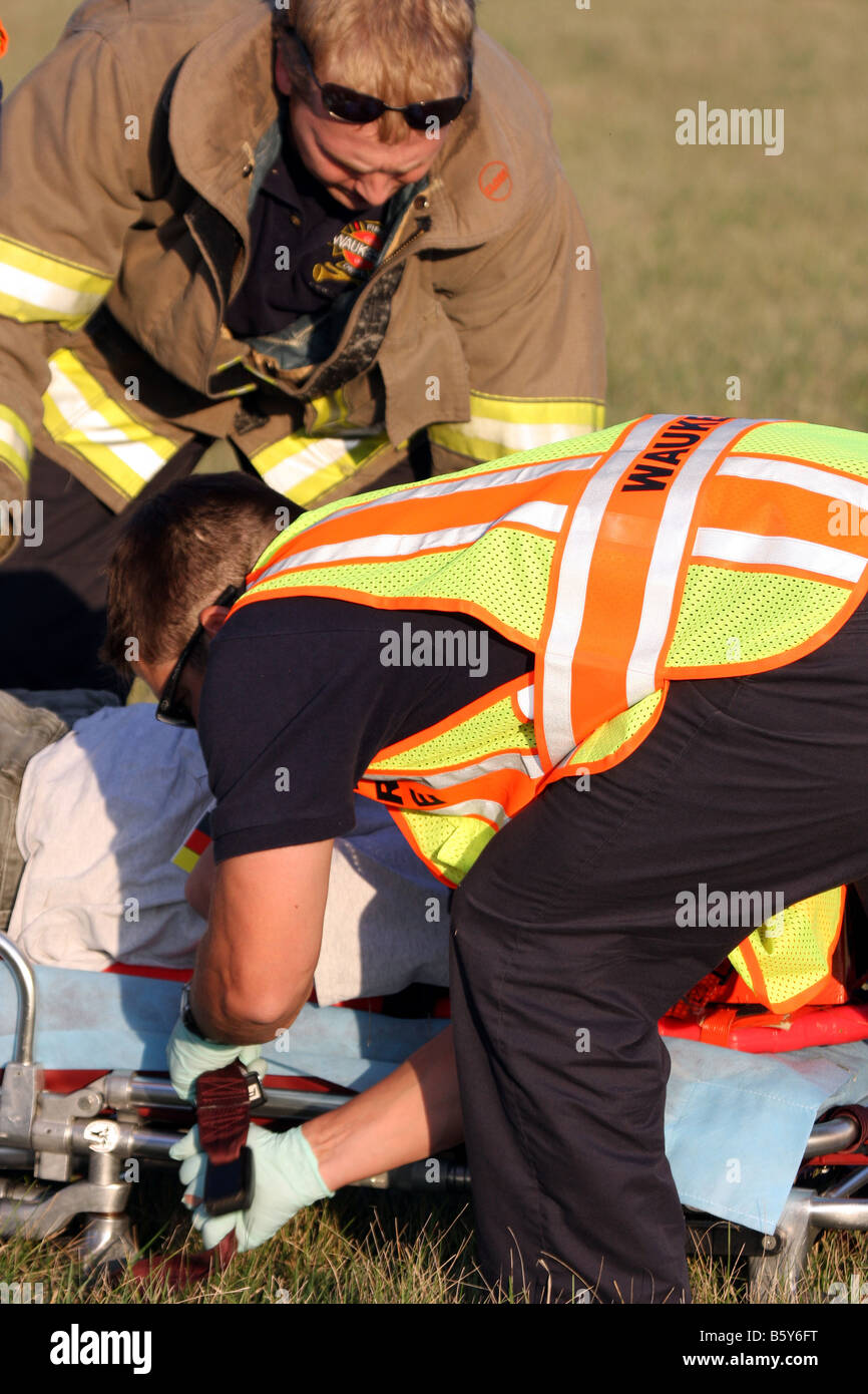 Two EMTs are strapping in a victim who was hurt on a stretcher Stock ...