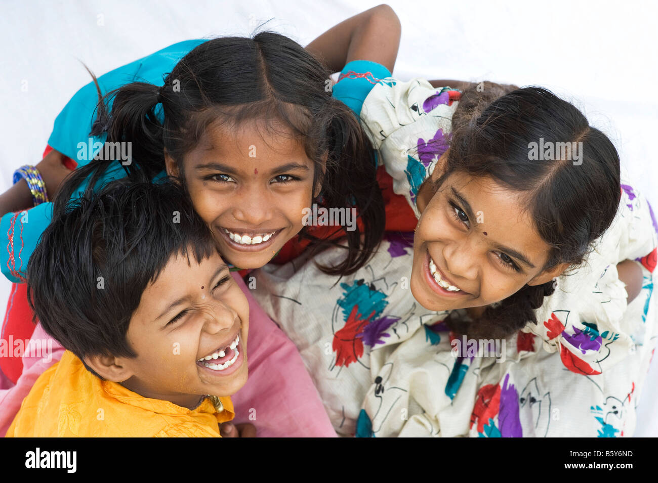 Three indian girl friends sitting together laughing at camera. Andhra ...