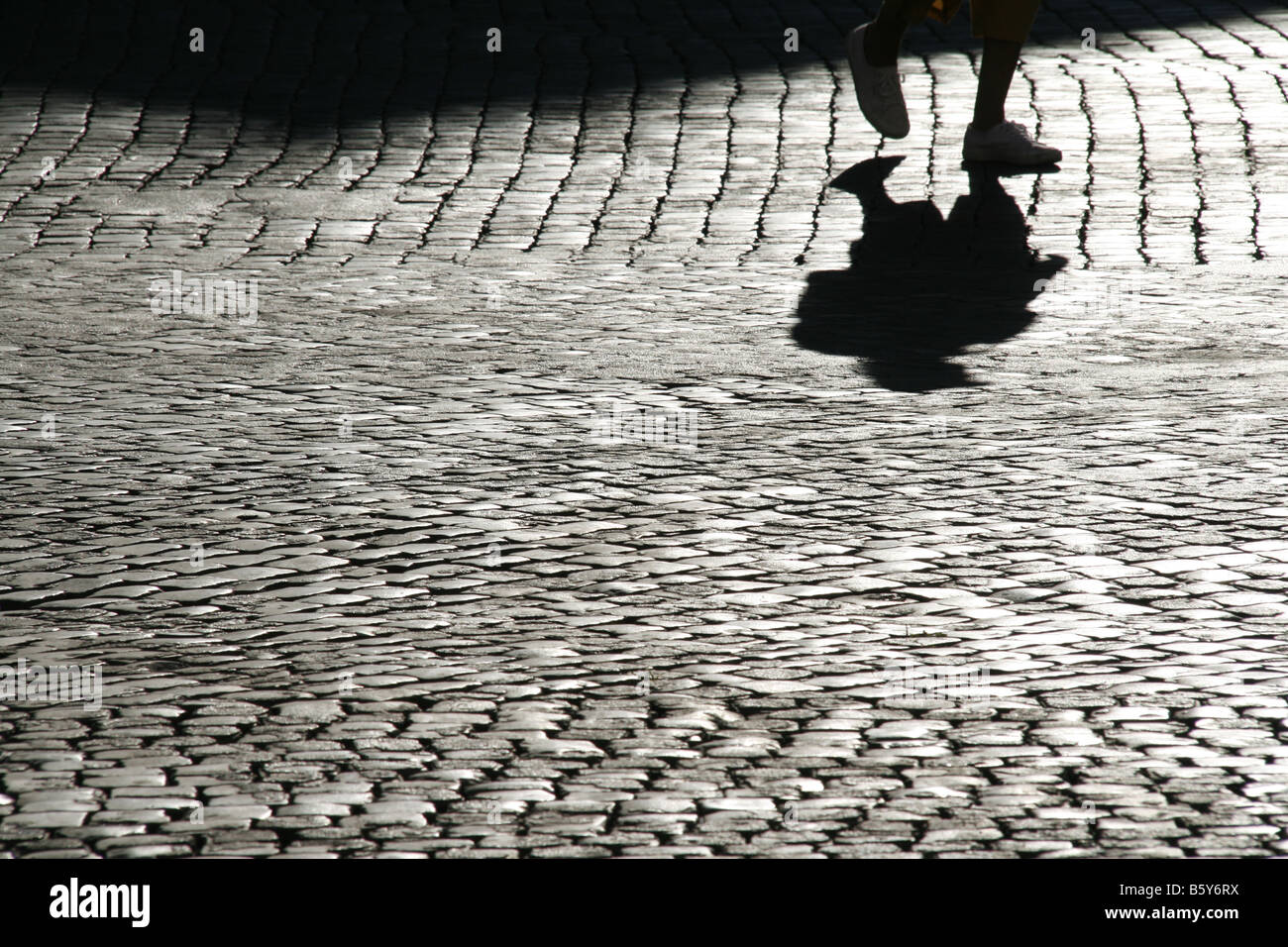 shadow person feet legs walking in street in town Stock Photo - Alamy