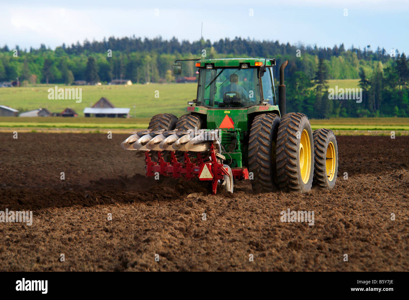 A tractor pulling a roll-over plow begins the ground preparation to ...