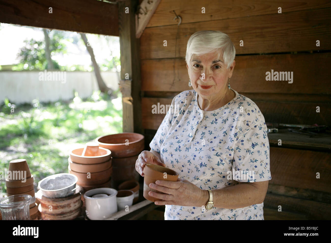 A sweet senior lady gardening in her potting shed Stock Photo - Alamy