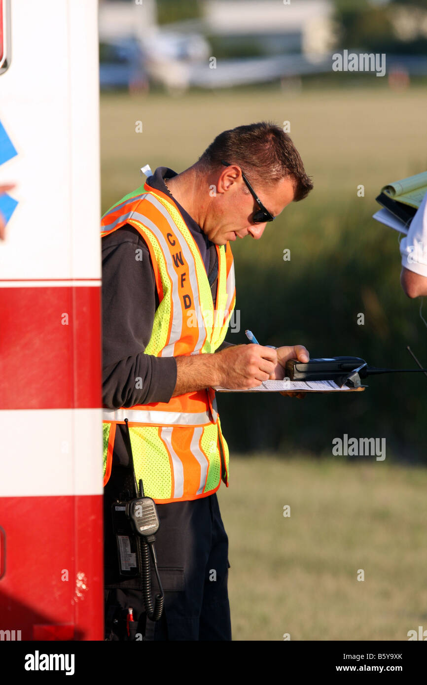 An EMT by an ambulance taking note on the mass casualty incident while ...