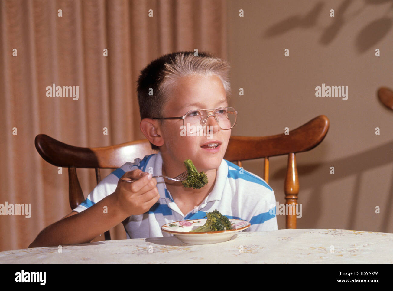 Boy eats broccoli Stock Photo - Alamy
