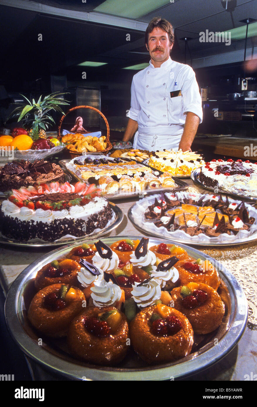 Pastry chef stands next to table of his productions Stock Photo - Alamy