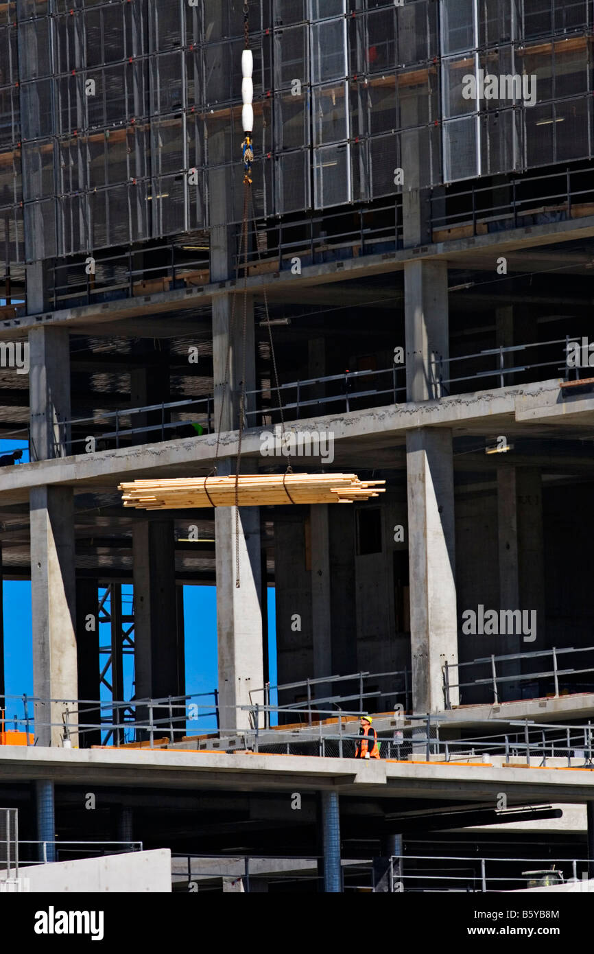 Construction / A Site Crane lifts a load of Timber above a high rise ...