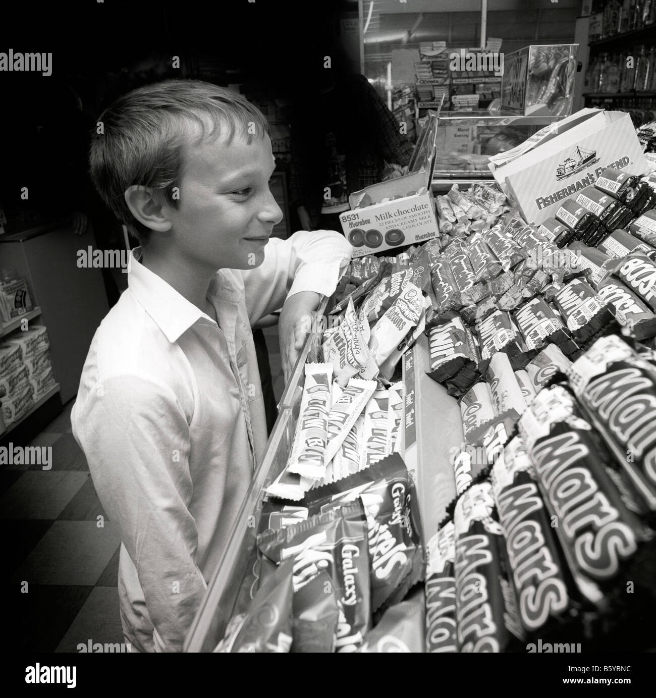 UK Childhood child in sweet shop tempted by array of chocolate bars ...