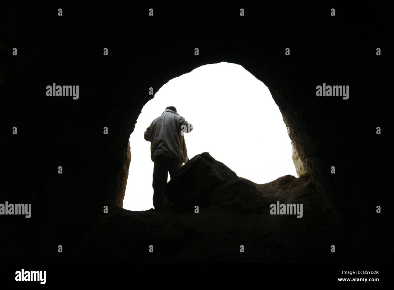 dark figure man silhouette standing inside dark cav Stock Photo - Alamy
