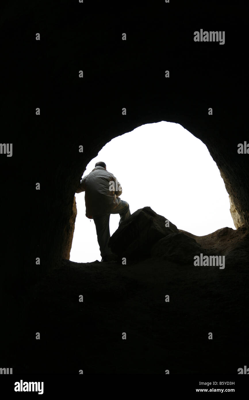 dark figure man silhouette standing inside dark cav Stock Photo - Alamy